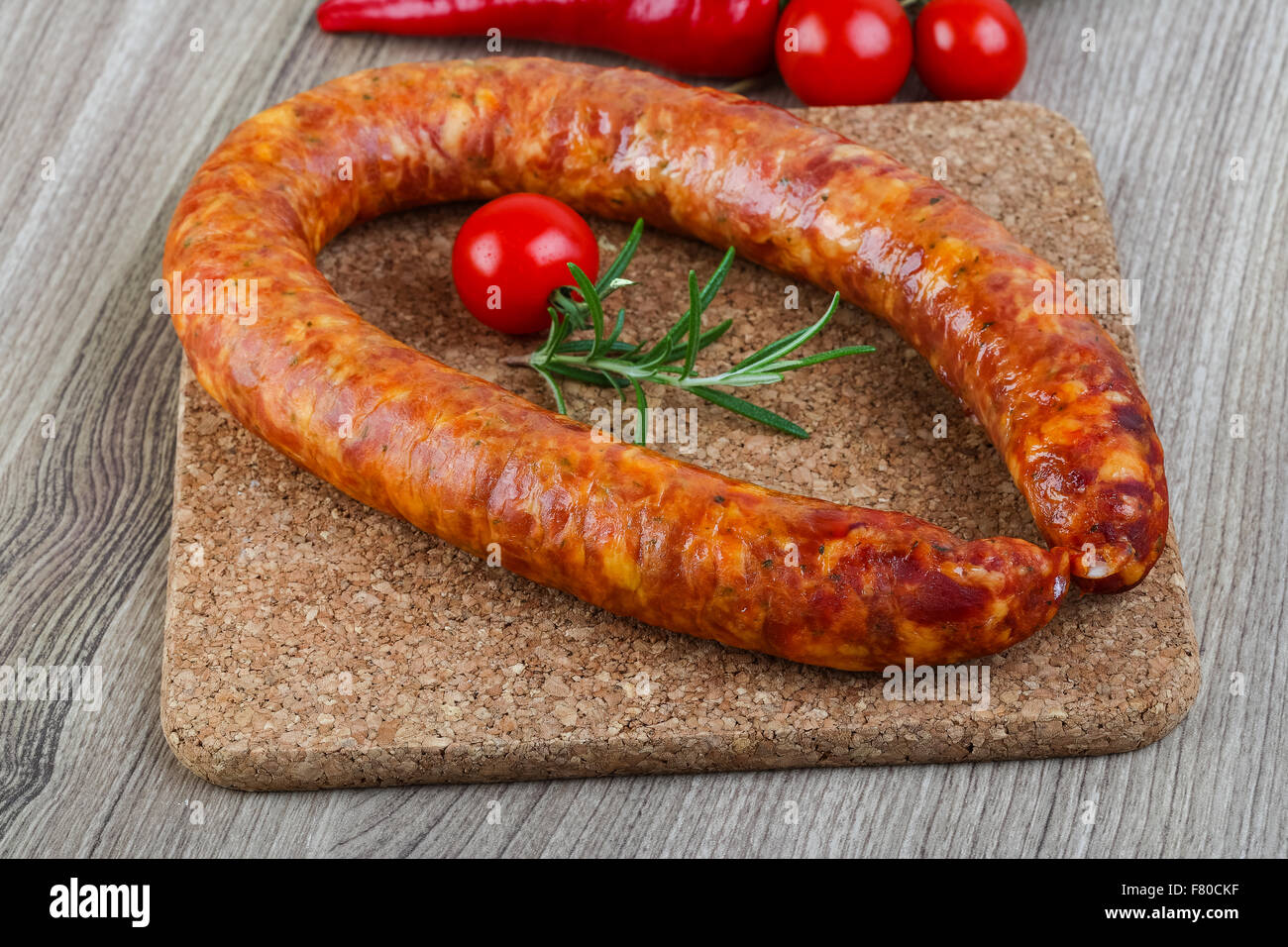 Sausage ring with rosemary and pepper on the wood background Stock ...