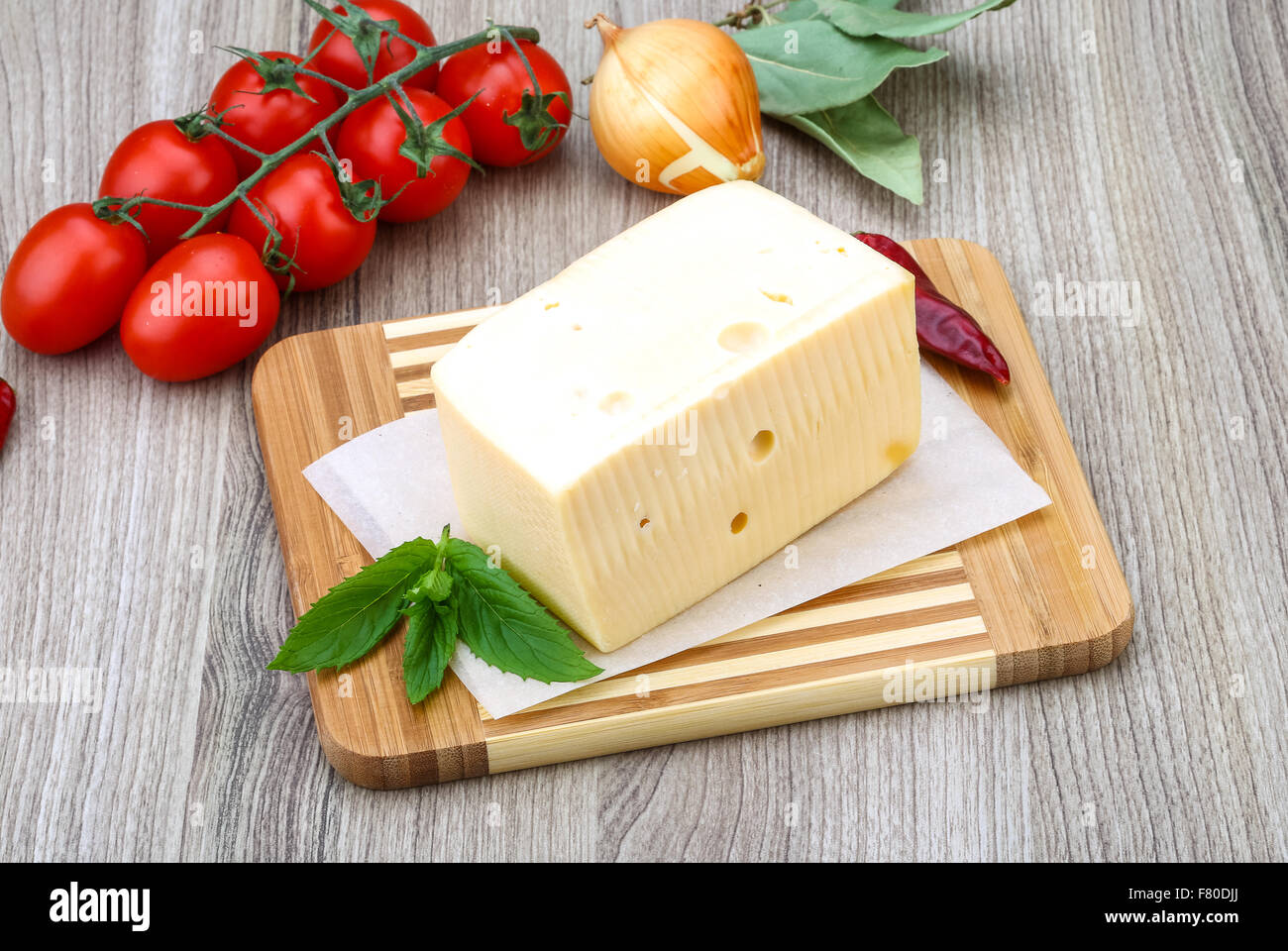 Cheese brick with mint leaves on the wood background Stock Photo - Alamy