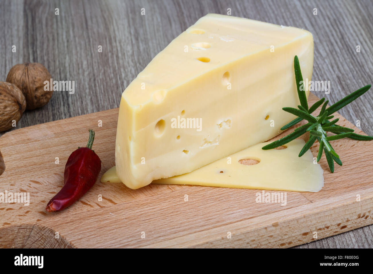 Yellow young cheese with pepper, rosemary and walnuts Stock Photo - Alamy
