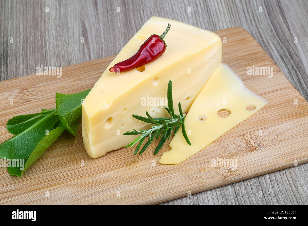 Yellow Cheese triangle with rosemary on the wood background Stock Photo ...