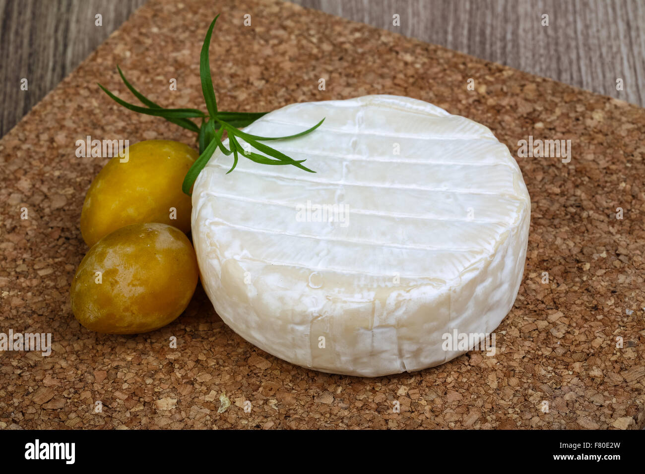 Round Brie cheese with yellow plums and estragon Stock Photo - Alamy