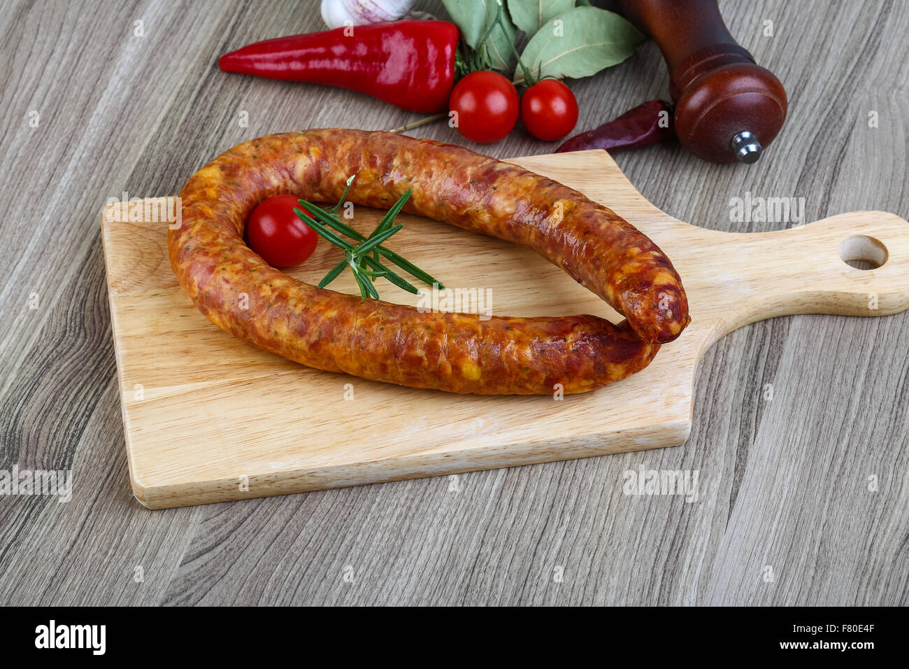 Sausage ring with rosemary and pepper on the wood background Stock ...