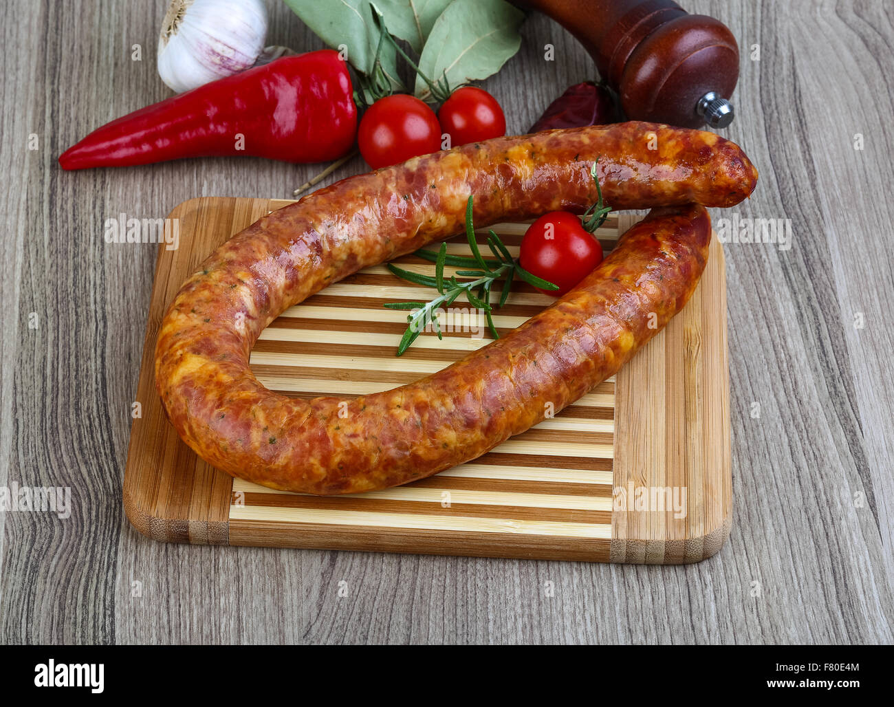 Sausage ring with rosemary and pepper on the wood background Stock ...