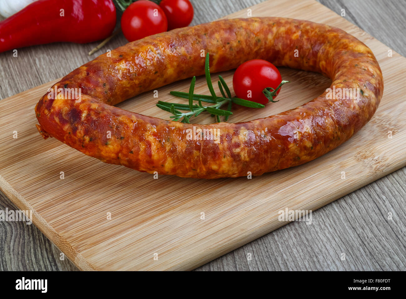 Sausage ring with rosemary and pepper on the wood background Stock ...