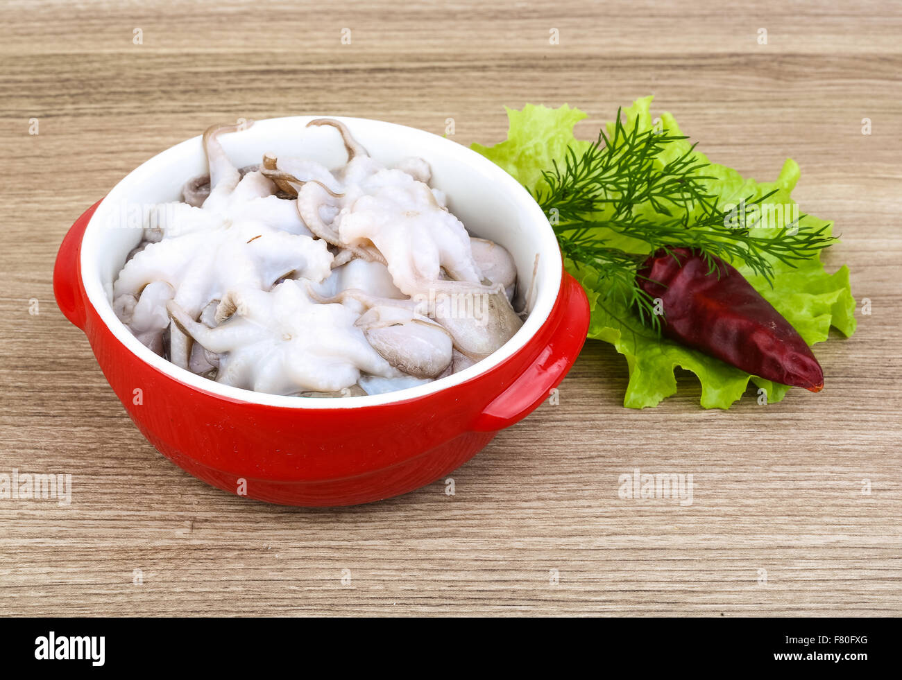 Raw baby octopus in the bowl ready for cooking Stock Photo - Alamy