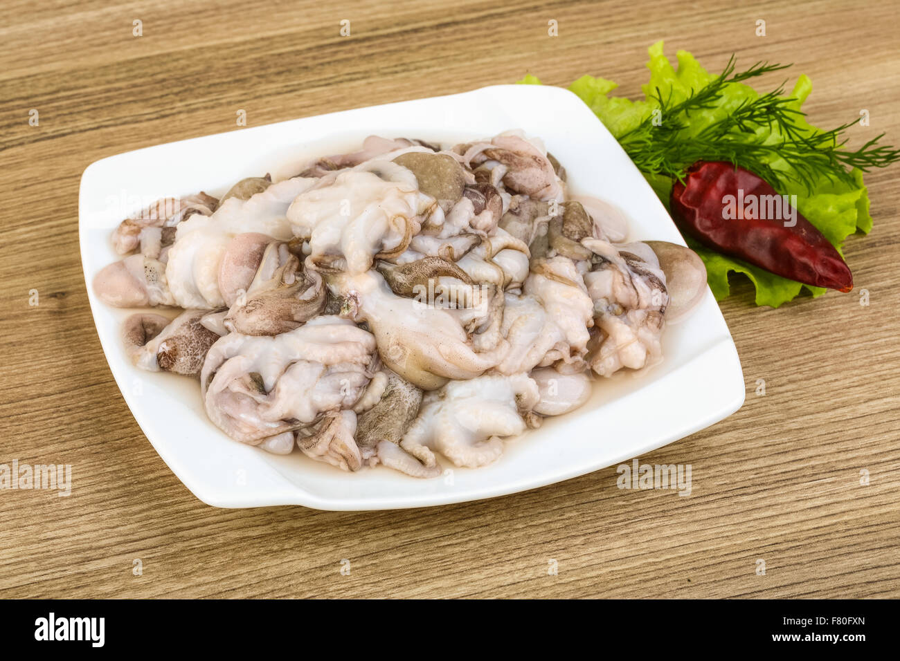 Raw baby octopus in the bowl ready for cooking Stock Photo - Alamy