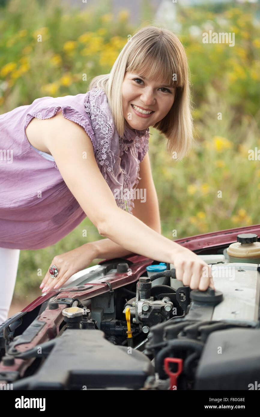 Blonde woman trying to fix the car Stock Photo - Alamy