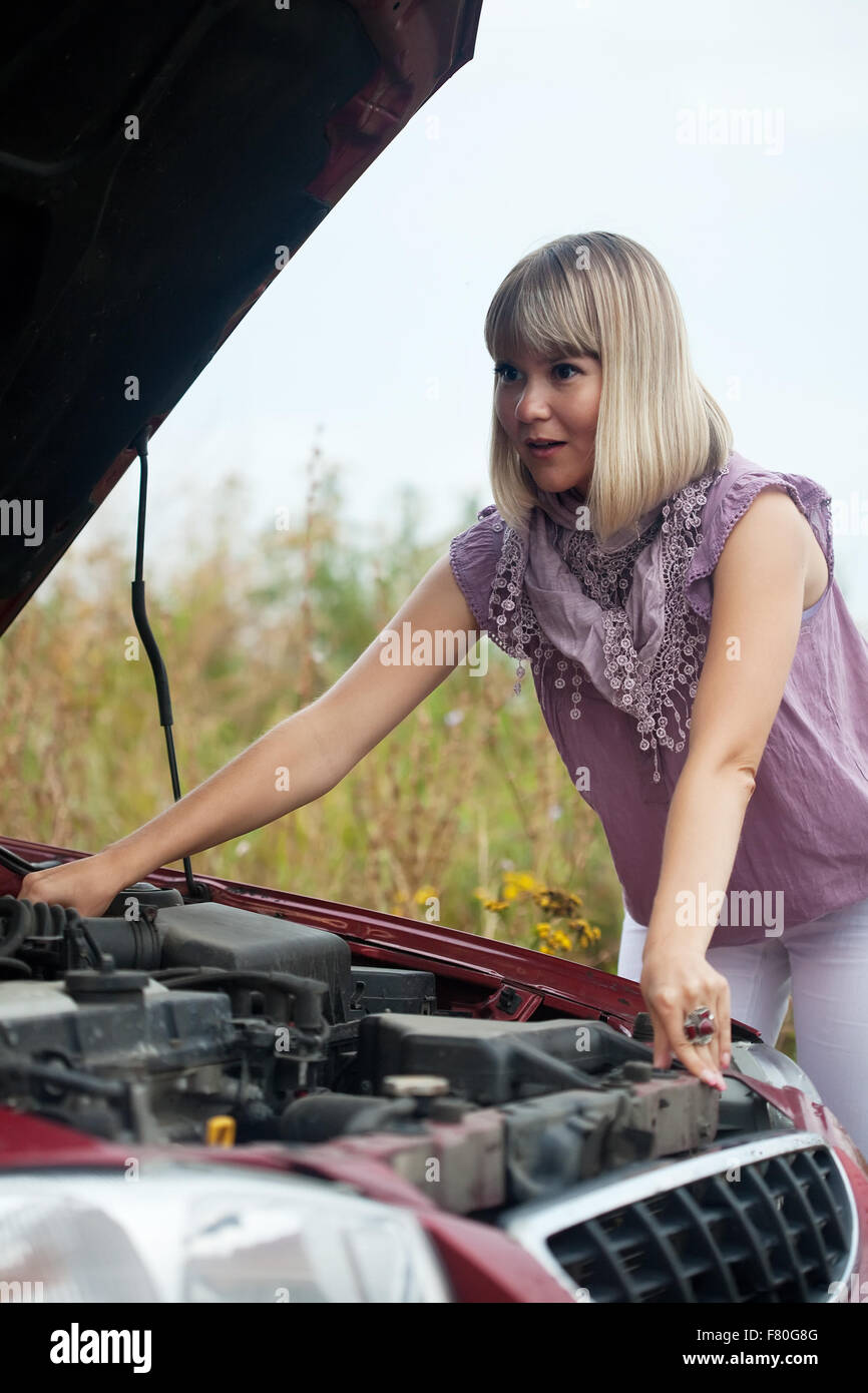 Blonde woman trying to fix the car Stock Photo - Alamy