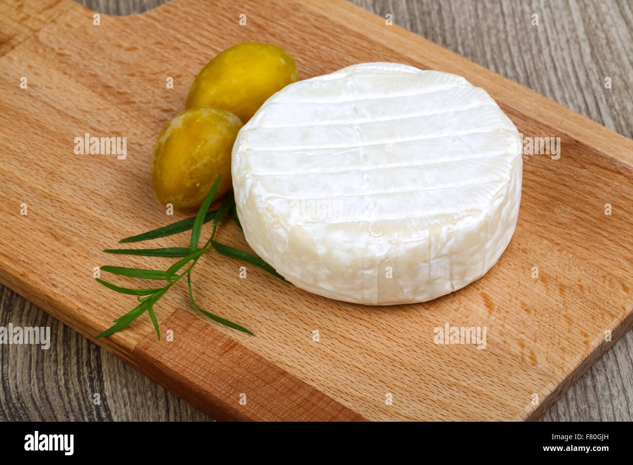 Round Brie cheese with yellow plums and estragon Stock Photo - Alamy
