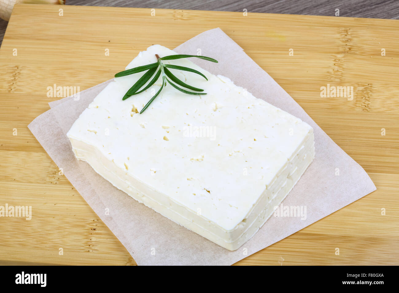 White bulgarian cheese brinza with rosemary on the wood background ...