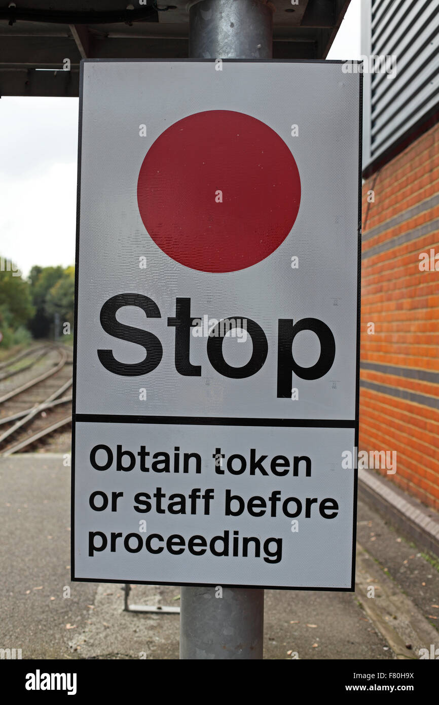 A large warning sign in white with black lettering and a large red disc ...