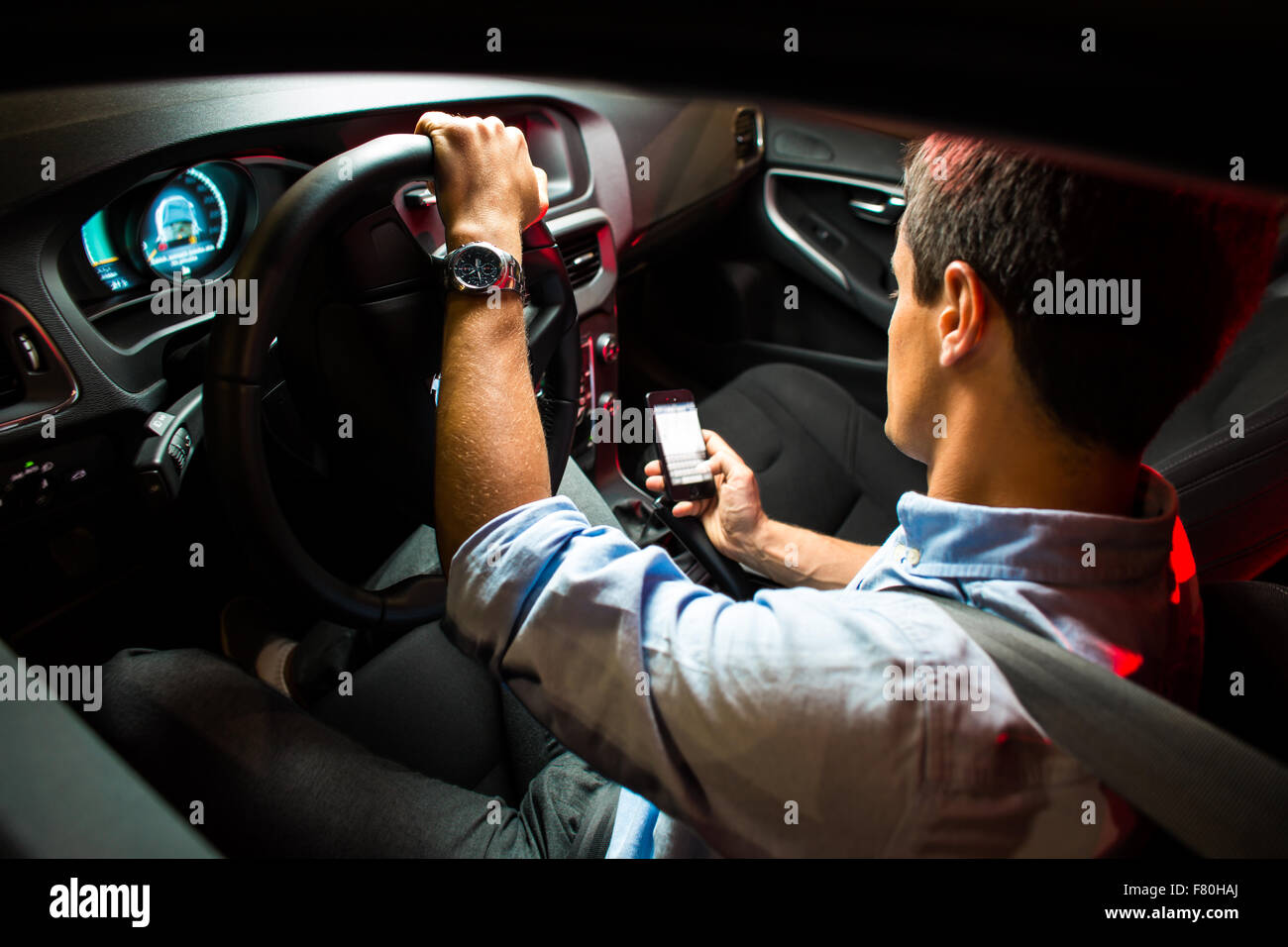 Driving a car at night - young man driving her modern car at night, in ...