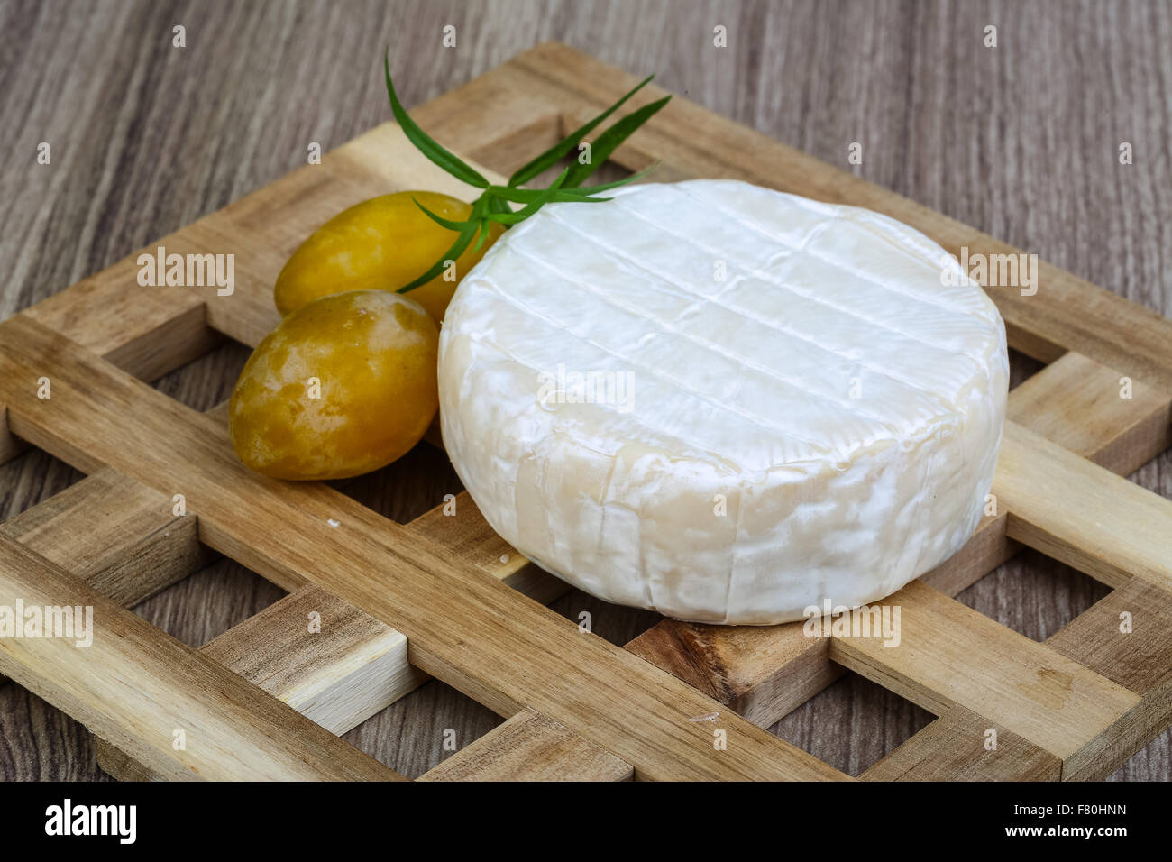 Round Brie cheese with yellow plums and estragon Stock Photo - Alamy