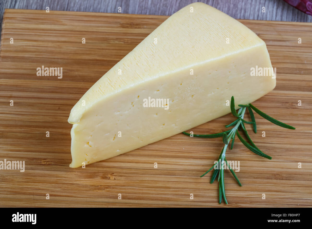 Yellow cheese triangle with rosemary herbs on the wood background Stock ...