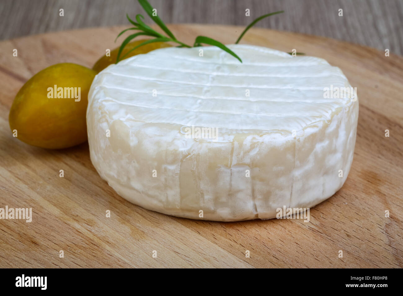 Round Brie cheese with yellow plums and estragon Stock Photo - Alamy