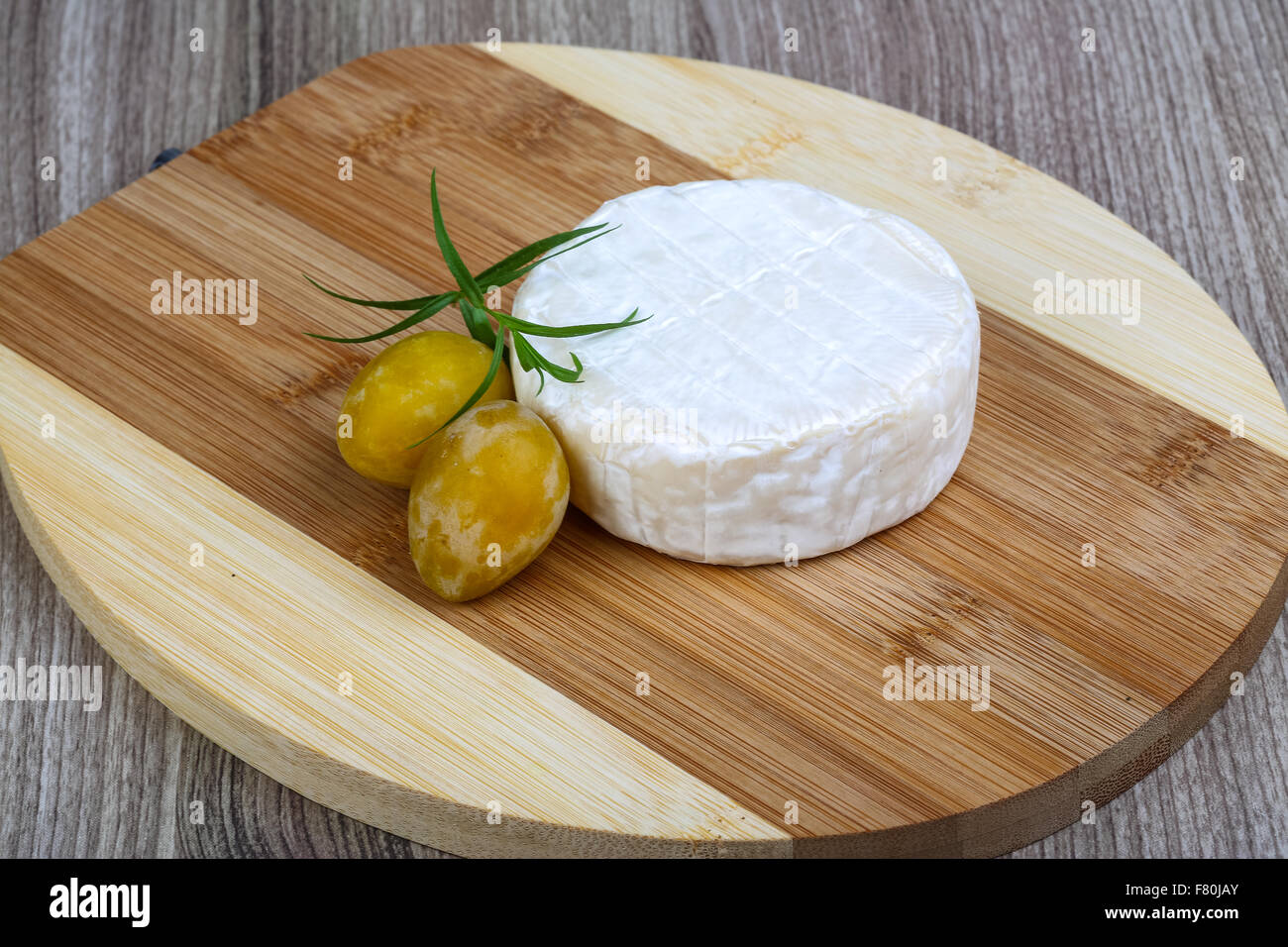 Round Brie cheese with yellow plums and estragon Stock Photo - Alamy