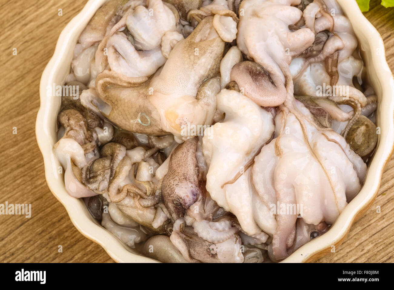 Raw baby octopus in the bowl ready for cooking Stock Photo - Alamy