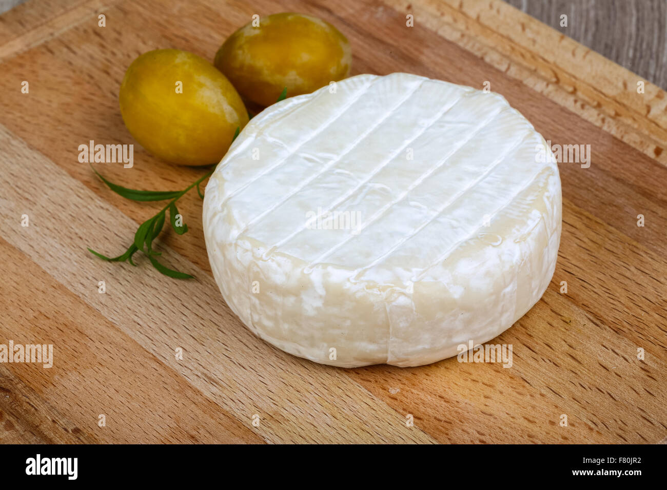 Round Brie cheese with yellow plums and estragon Stock Photo - Alamy