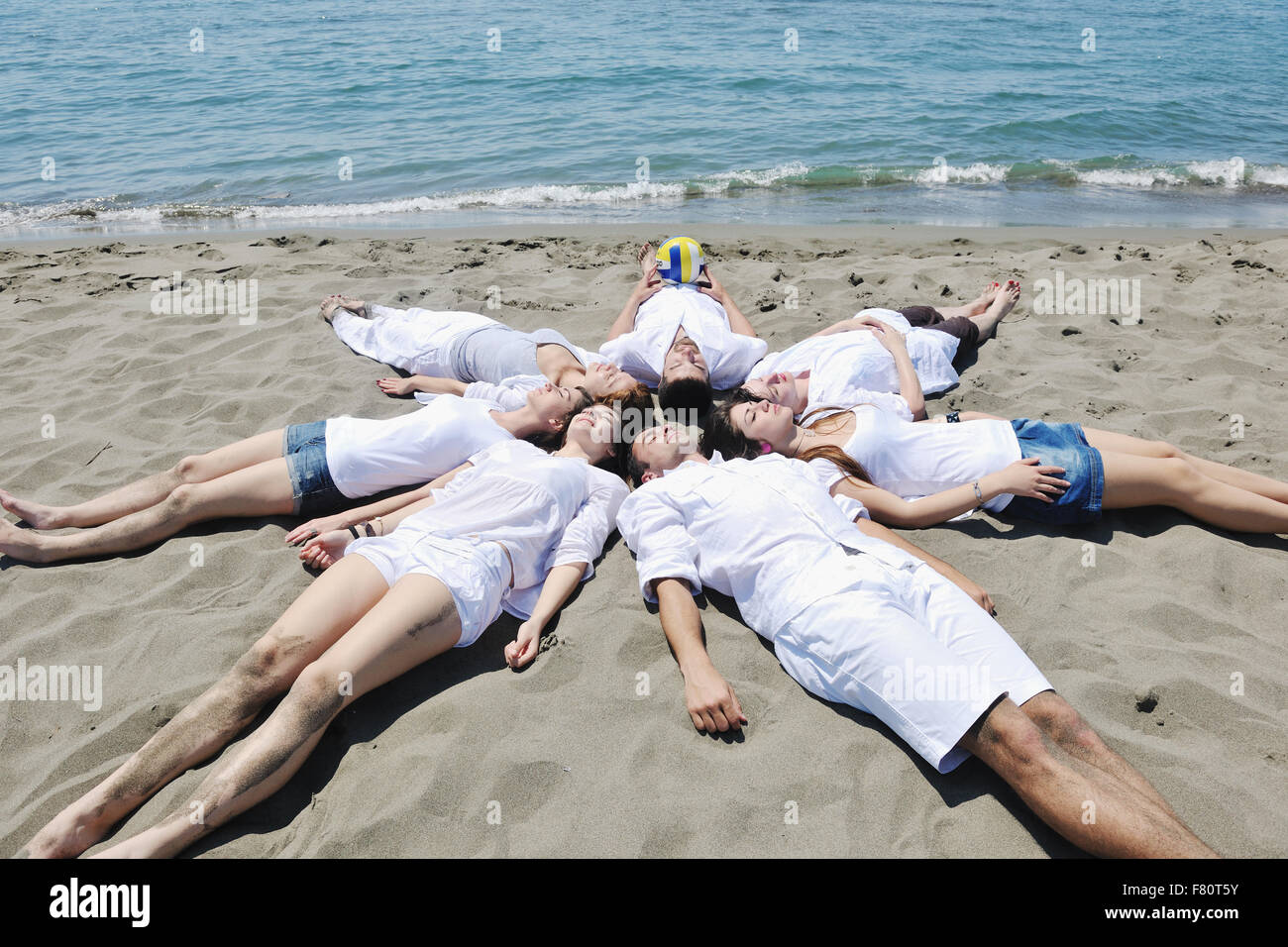 Group of happy young people in circle at beach have fun Stock Photo - Alamy