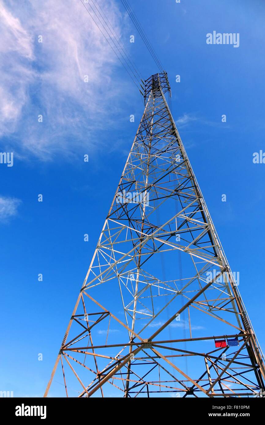 A tall high voltage electricity power mast against a blue sky Stock ...