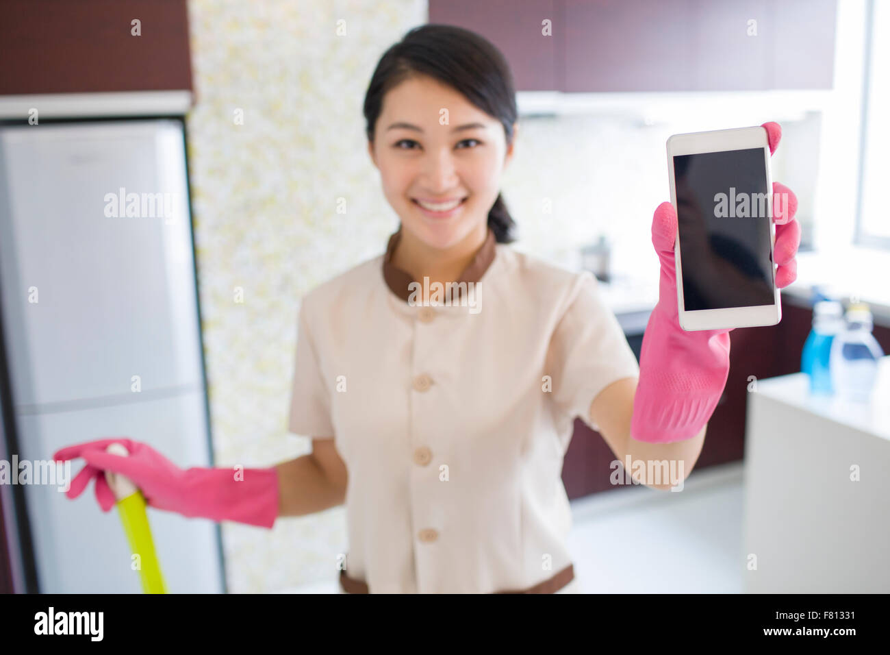 Domestic staff showing smart phone Stock Photo - Alamy
