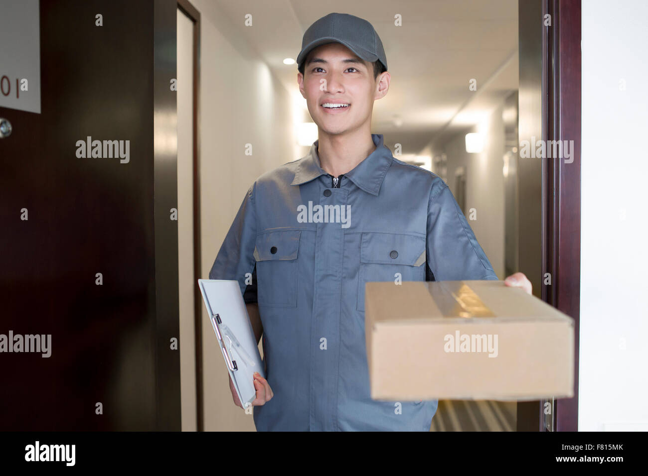 Delivery person holding package Stock Photo - Alamy