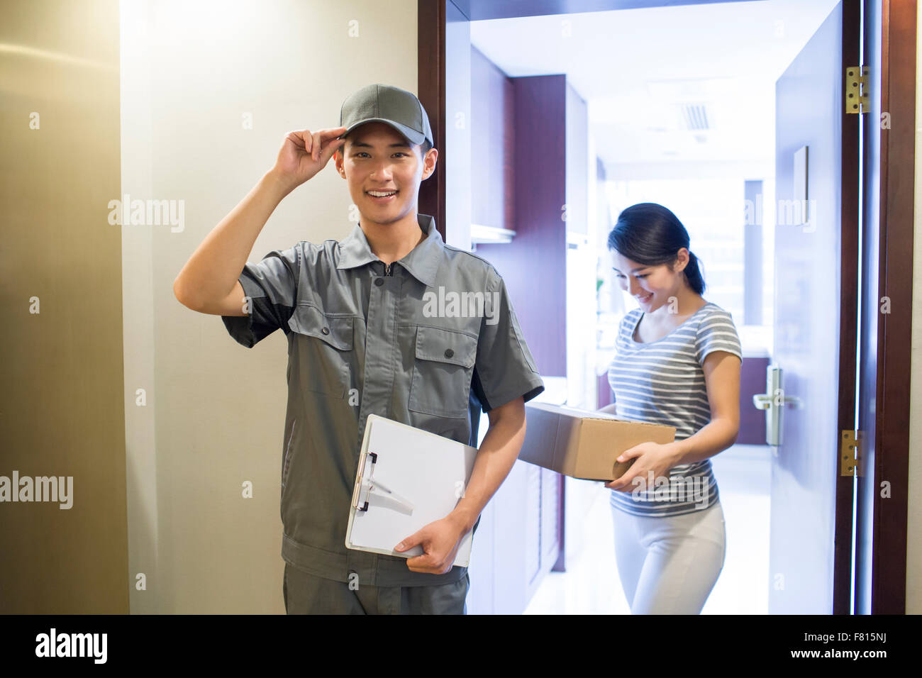 Woman receiving delivery front door hi-res stock photography and images ...