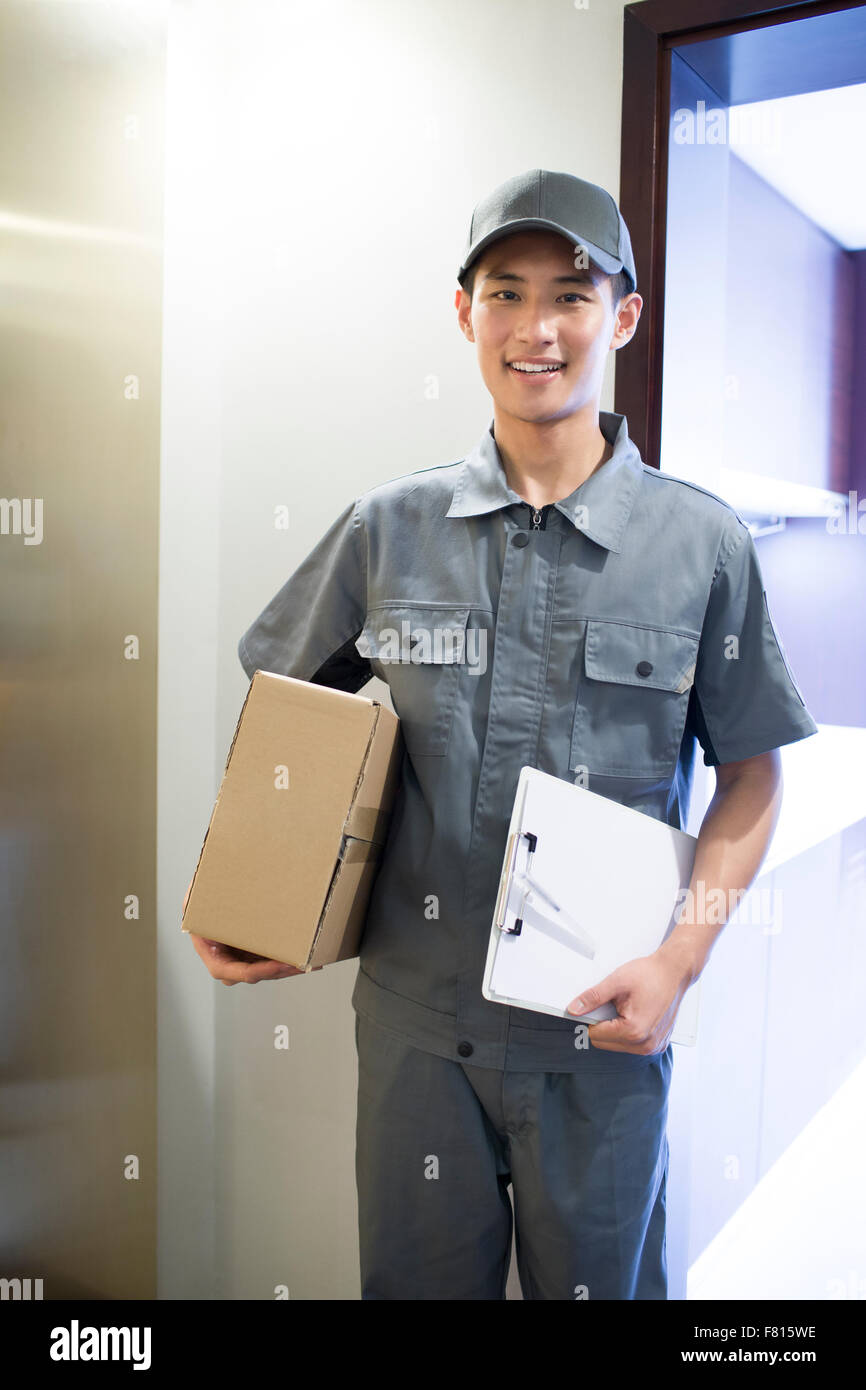 Delivery person holding package Stock Photo - Alamy