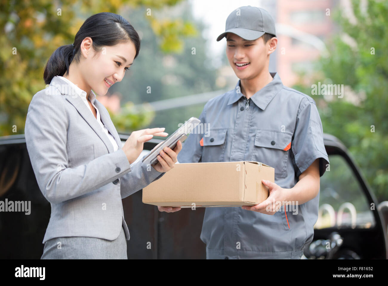 Young woman signing for the package Stock Photo - Alamy