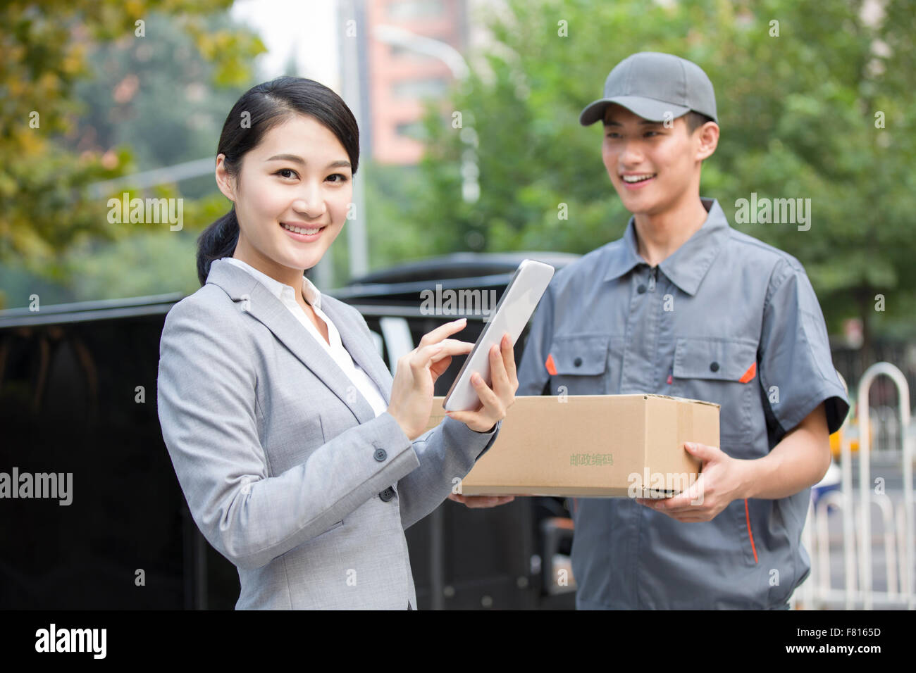 Young woman signing for the package Stock Photo - Alamy