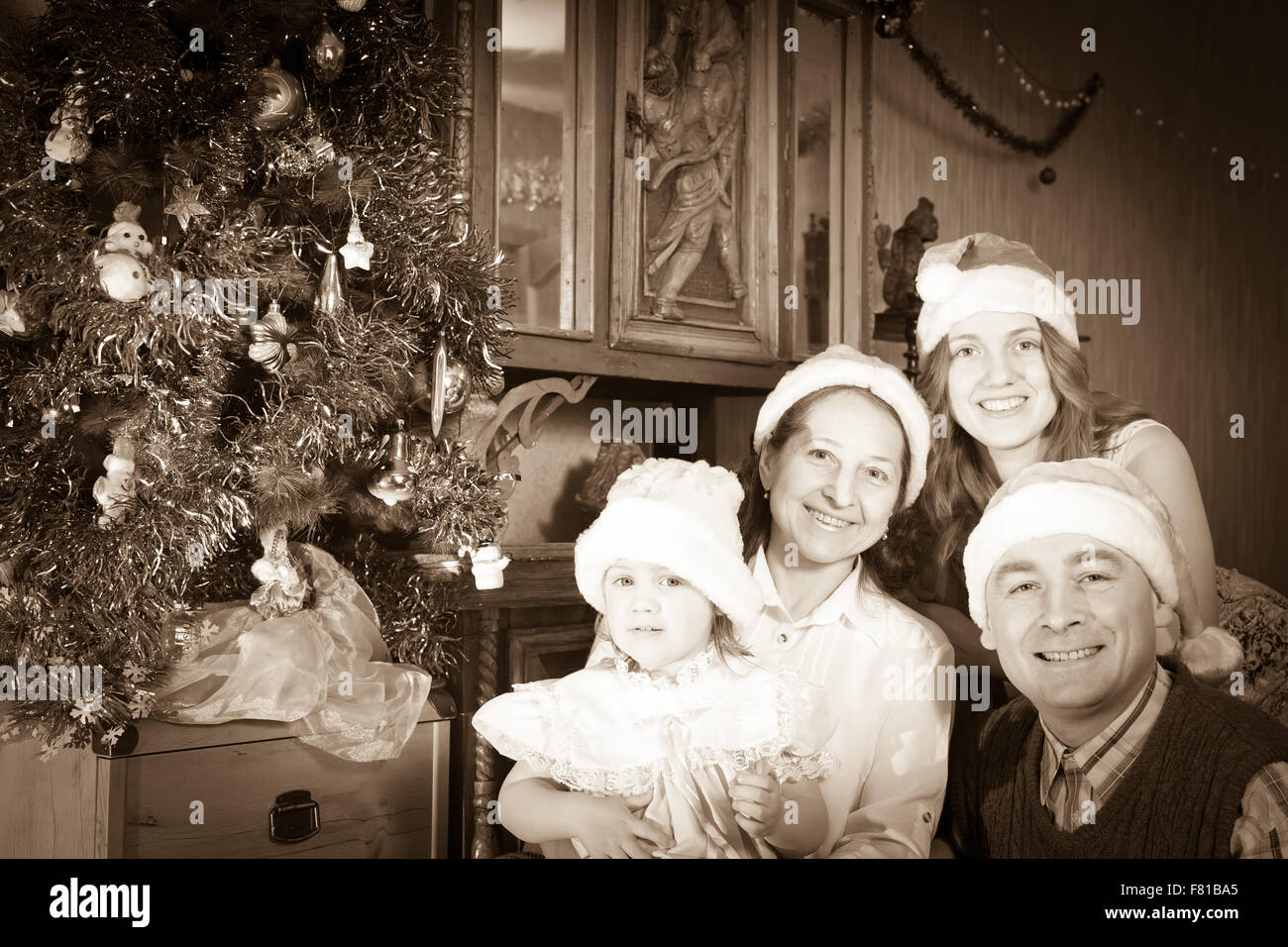 Vintage photo of happy family of three generations at Christmas time or ...