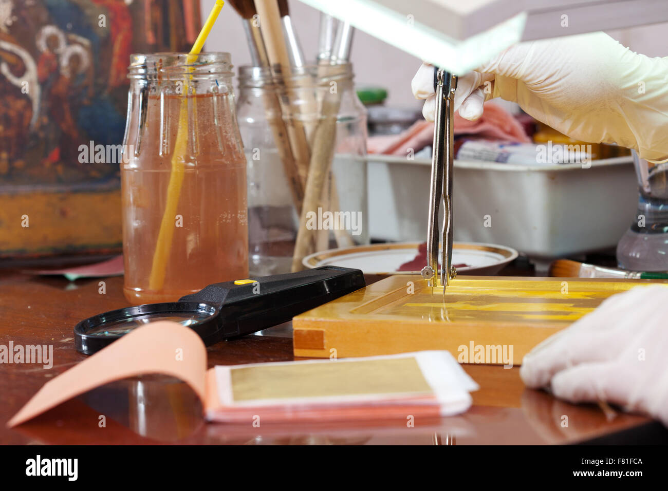 Iconographer works on new gilded icon with compasses at workshop Stock ...