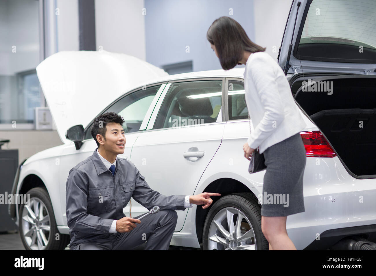 Auto mechanic talking with car owner Stock Photo - Alamy