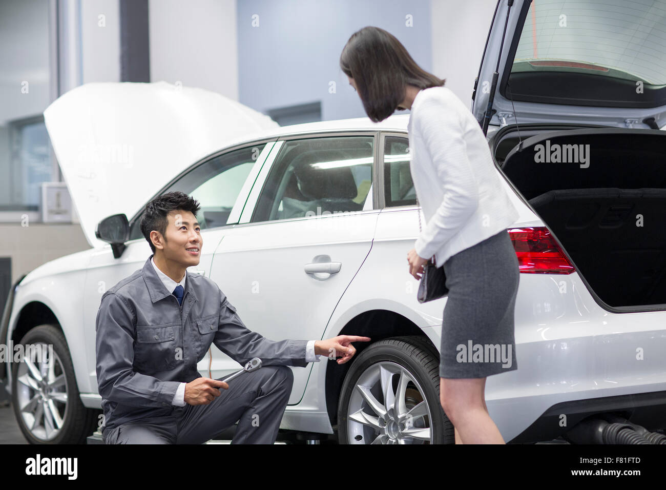 Auto mechanic talking with car owner Stock Photo - Alamy