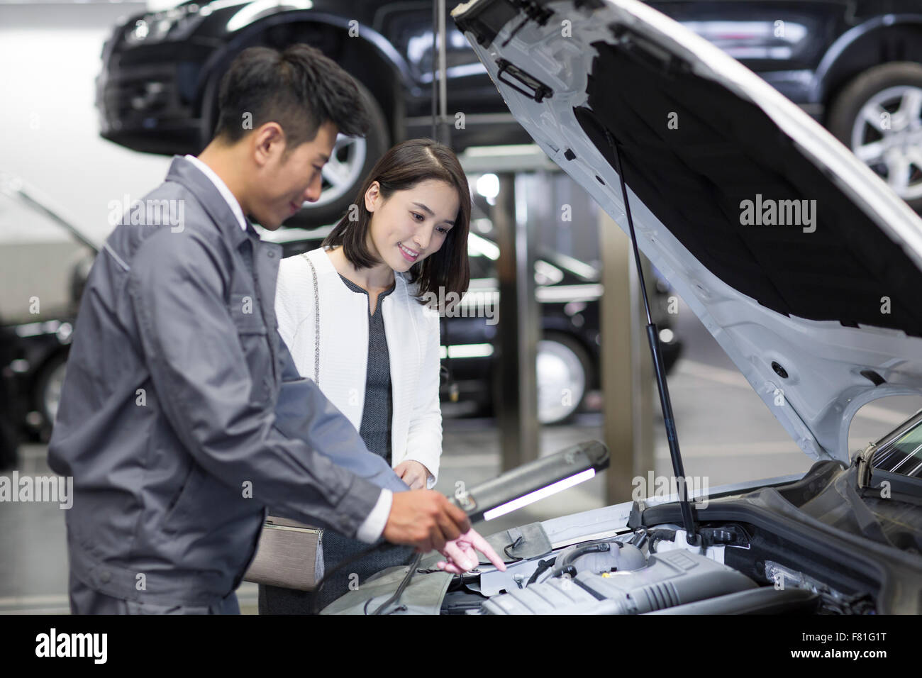 Auto mechanic talking with car owner Stock Photo - Alamy