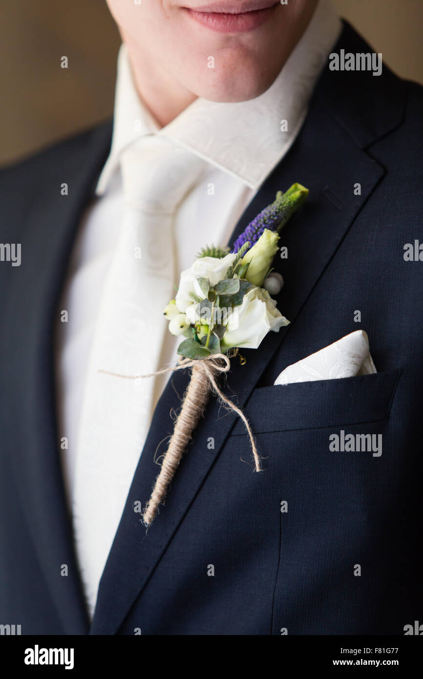 elegant white buttonhole of the groom in a black suit Stock Photo - Alamy