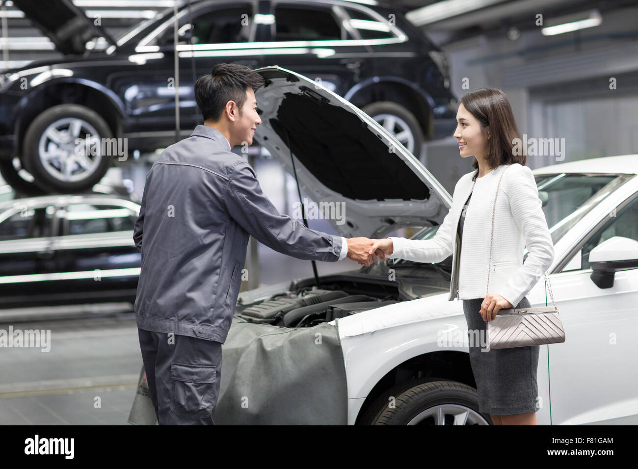 Auto mechanic and car owner shaking hands Stock Photo - Alamy