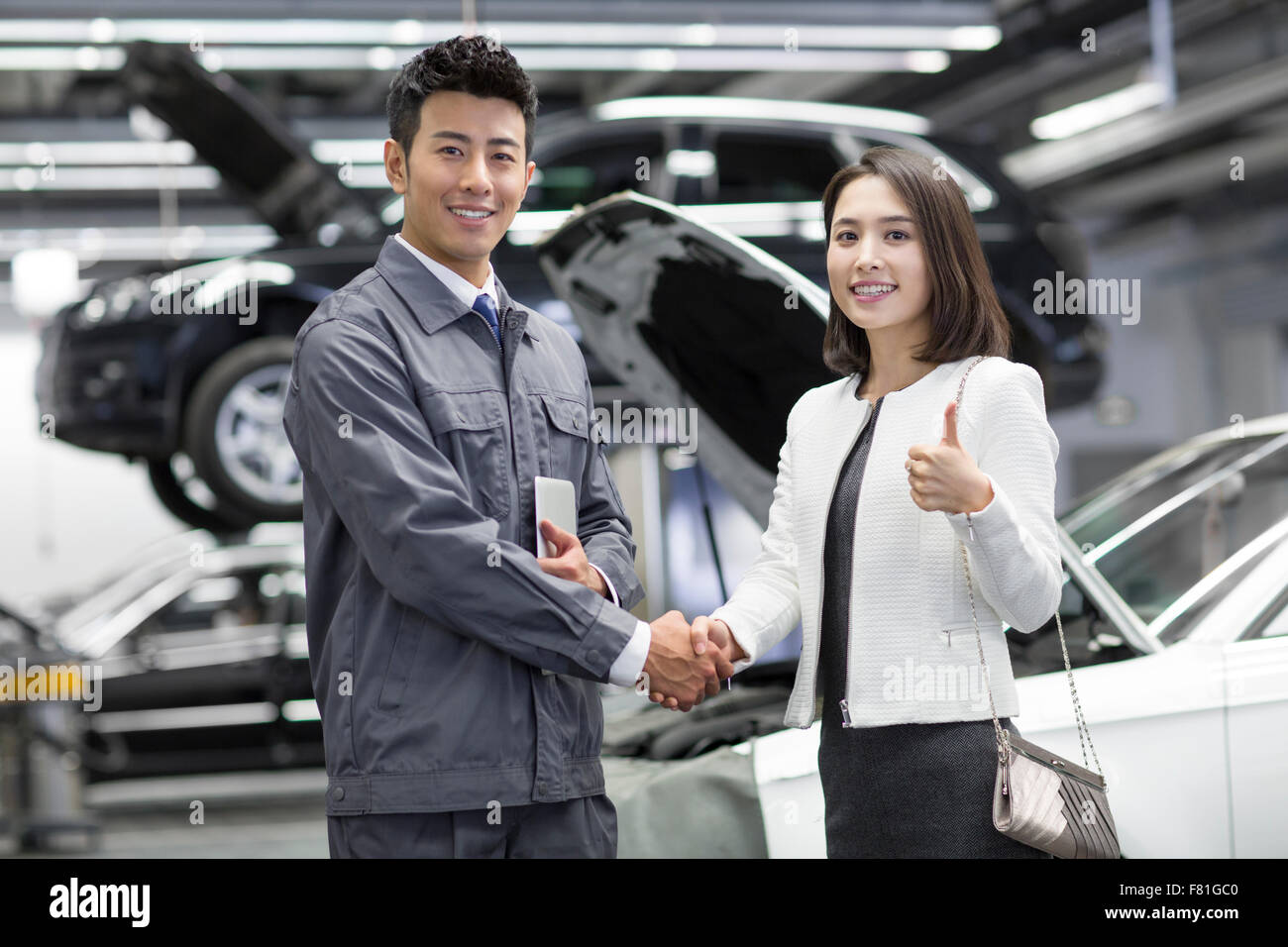 Auto mechanic and car owner shaking hands Stock Photo - Alamy