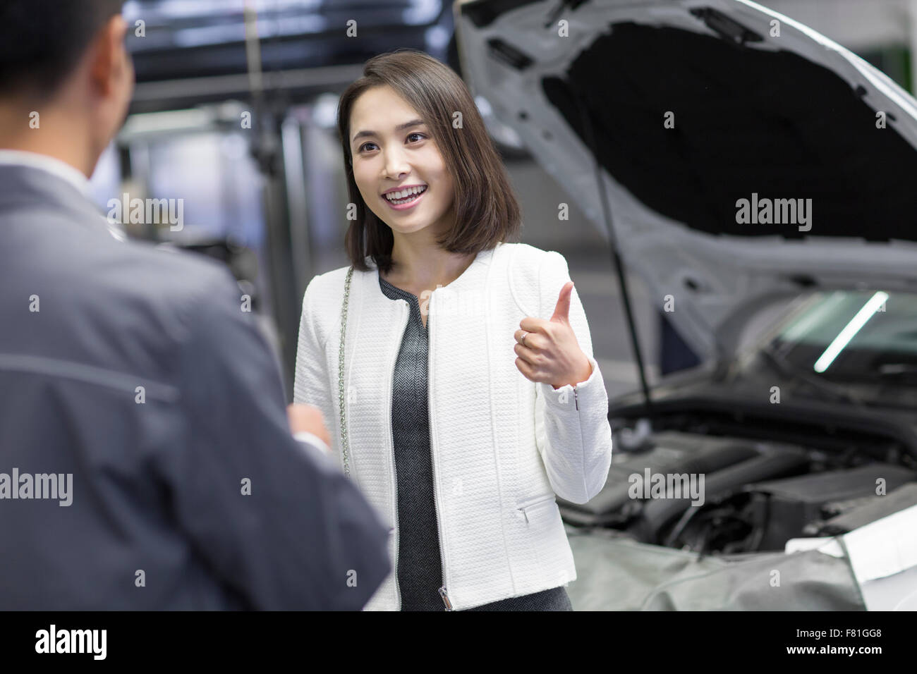 Auto mechanic talking with car owner Stock Photo - Alamy