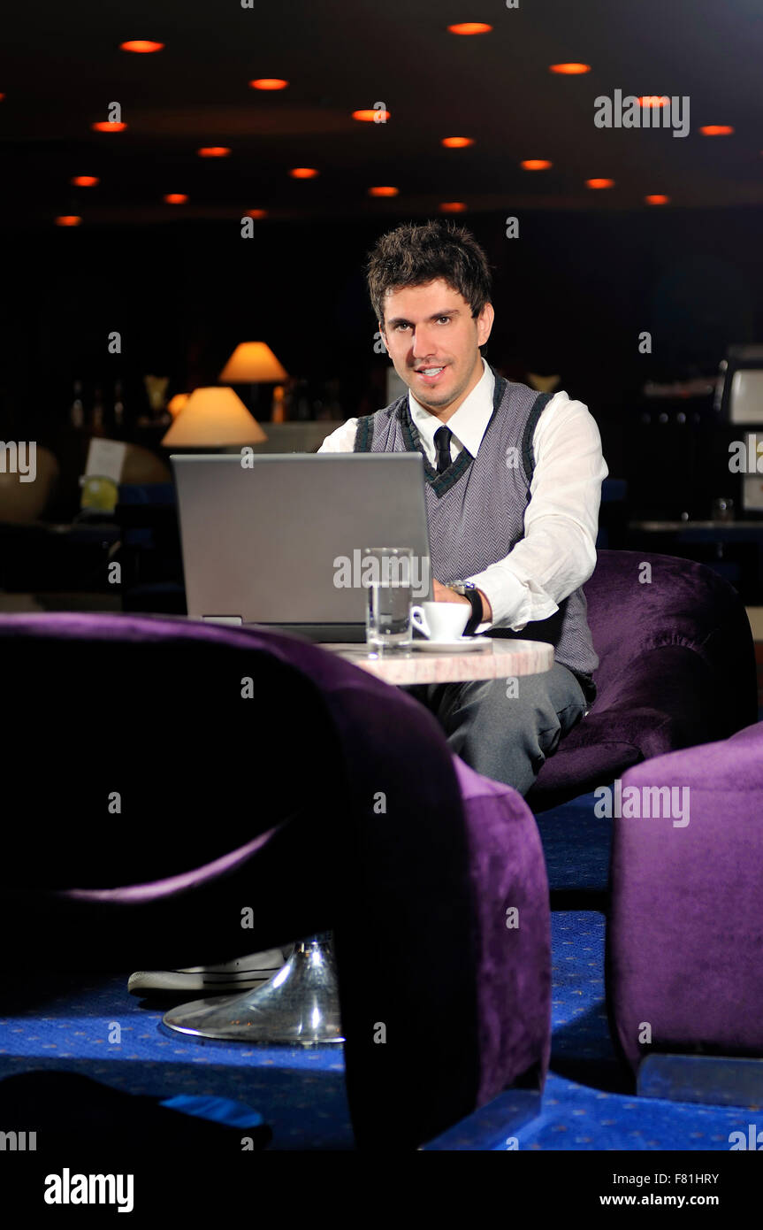 Happy young man sitting relaxed working on computer Stock Photo - Alamy