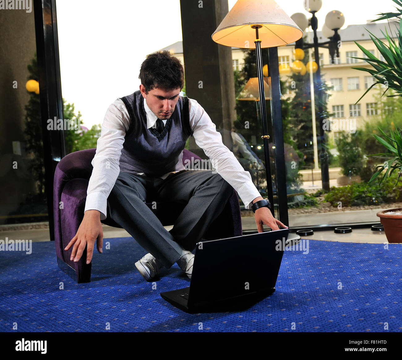 Happy young man sitting relaxed working on computer Stock Photo - Alamy