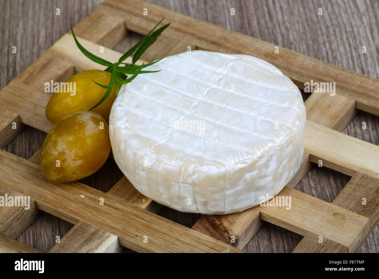 Round Brie cheese with yellow plums and estragon Stock Photo - Alamy