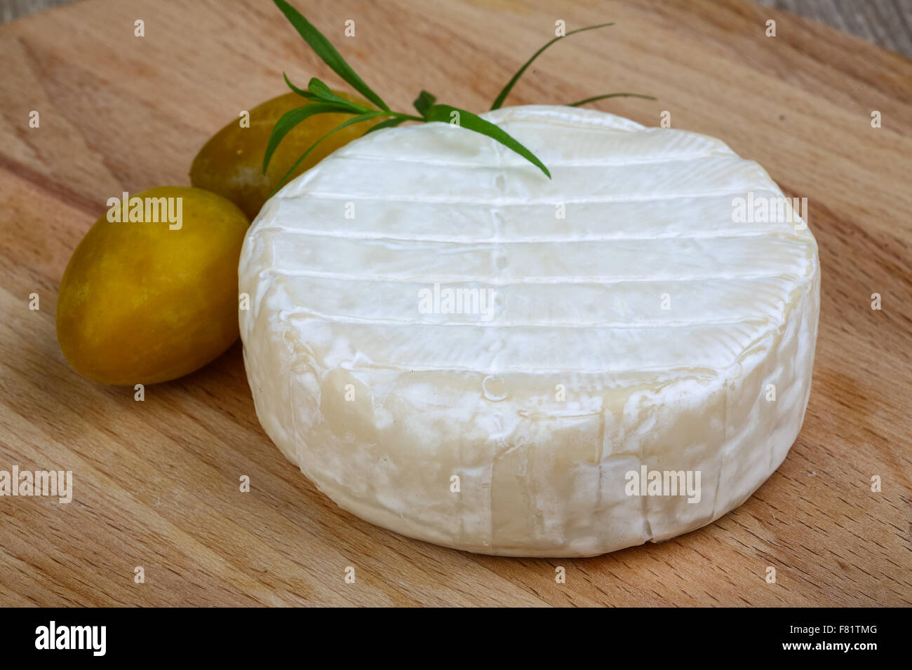 Round Brie cheese with yellow plums and estragon Stock Photo - Alamy