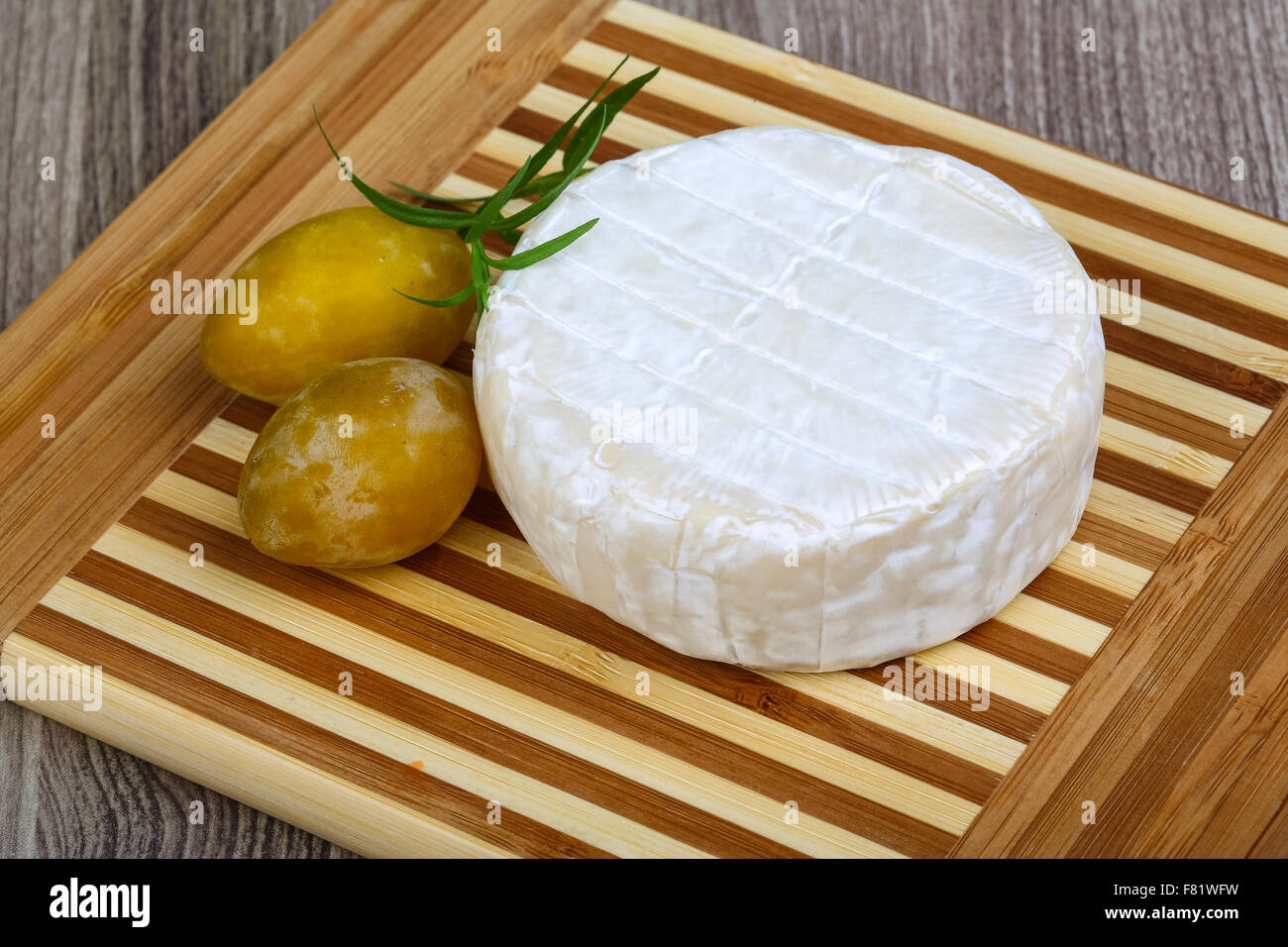 Round Brie cheese with yellow plums and estragon Stock Photo - Alamy