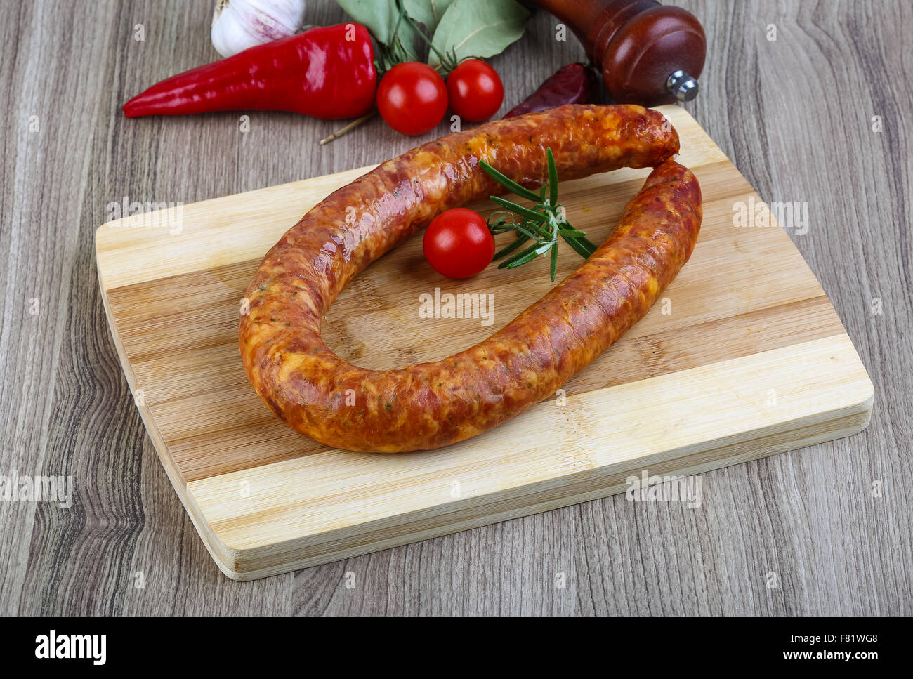 Sausage ring with rosemary and pepper on the wood background Stock ...