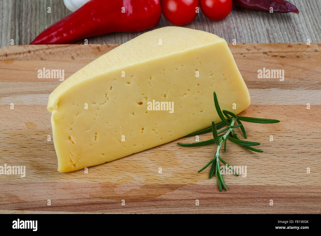 Yellow cheese triangle with rosemary herbs on the wood background Stock ...