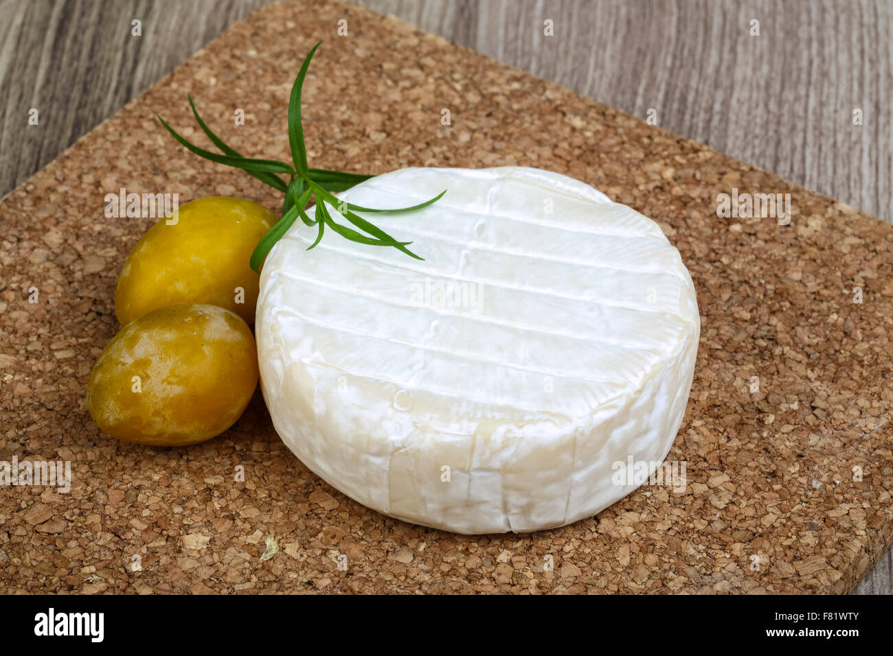 Round Brie cheese with yellow plums and estragon Stock Photo - Alamy