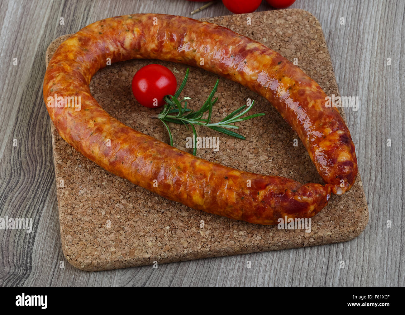 Sausage ring with rosemary and pepper on the wood background Stock ...