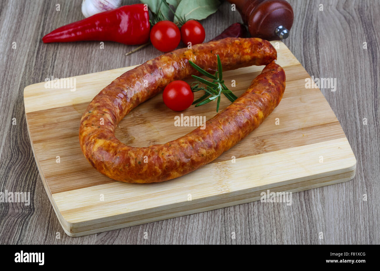 Sausage ring with rosemary and pepper on the wood background Stock ...