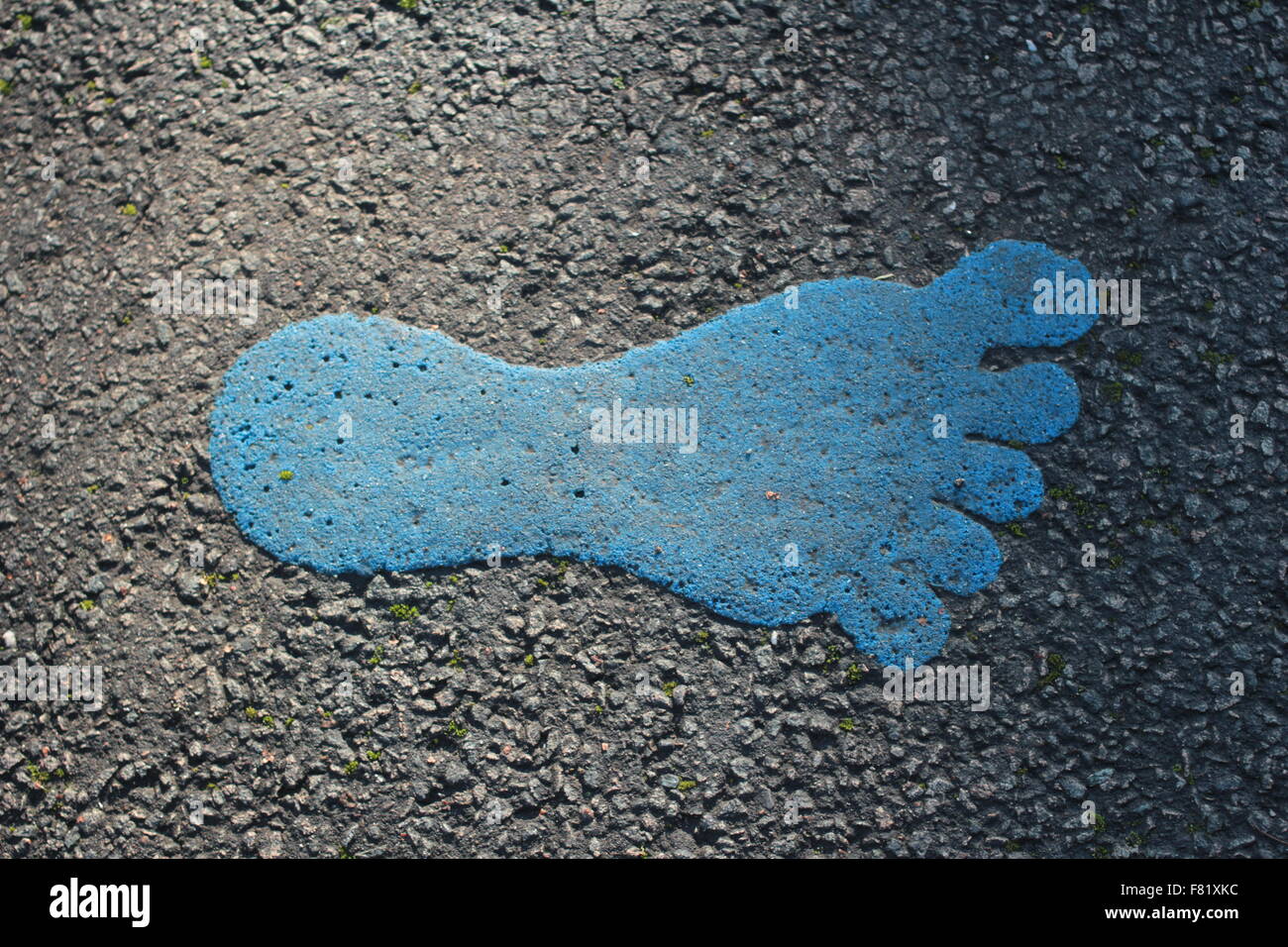 Big blue footprint on tarmac Stock Photo - Alamy